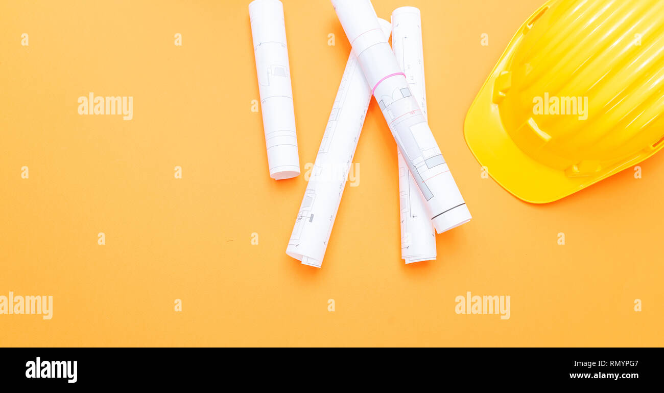 Construction project. Project paper blueprints and hard hat on yellow ...