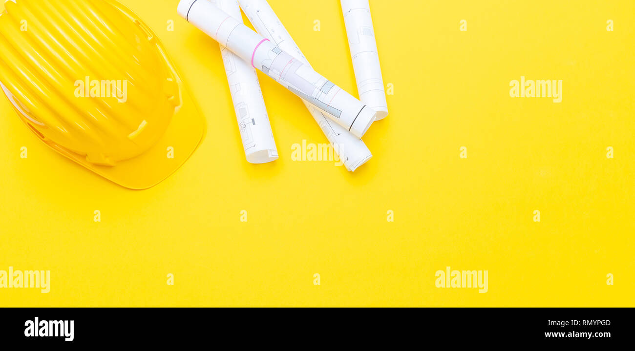 Construction project. Project paper blueprints and hard hat on yellow ...