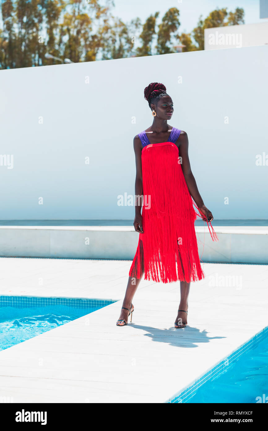 Attractive black woman wearing coral fringed dress walks the runway ...