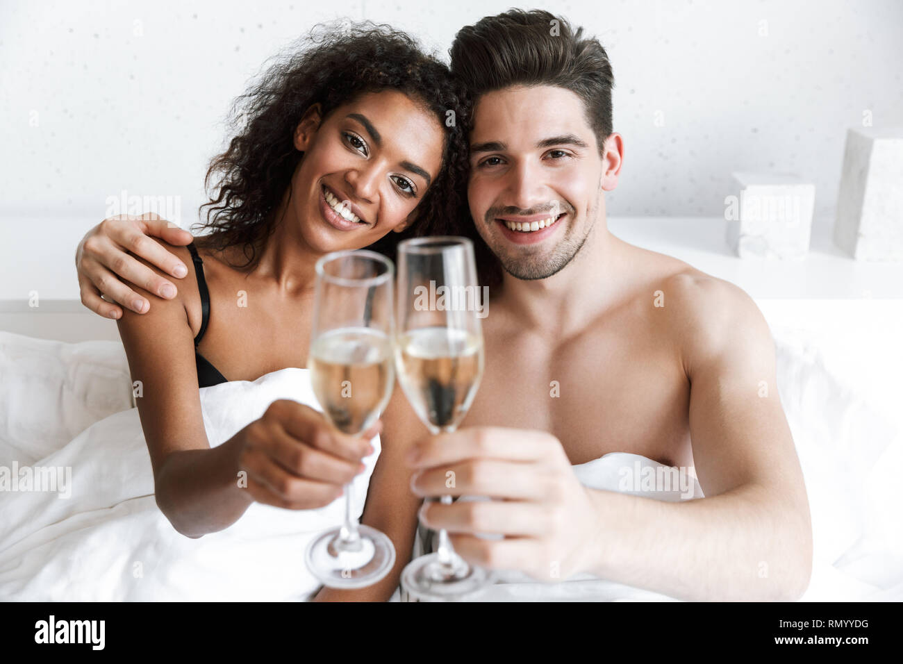 Beautiful Happy Young Multiethnic Couple Relaxing In Bed Under Blanket