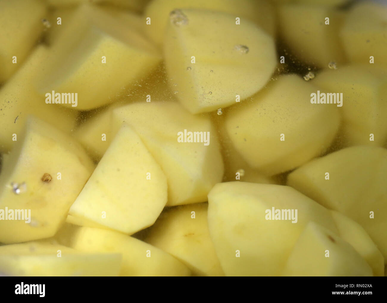 Peeled and chopped potato pieces underwater. There is some little ...