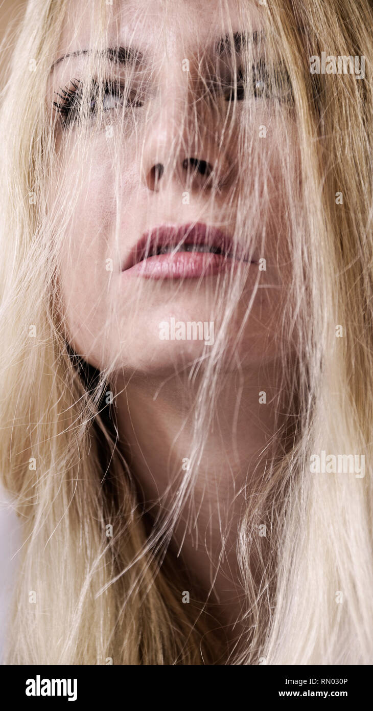 Beautiful young woman with hair over face with pensive expression Stock ...