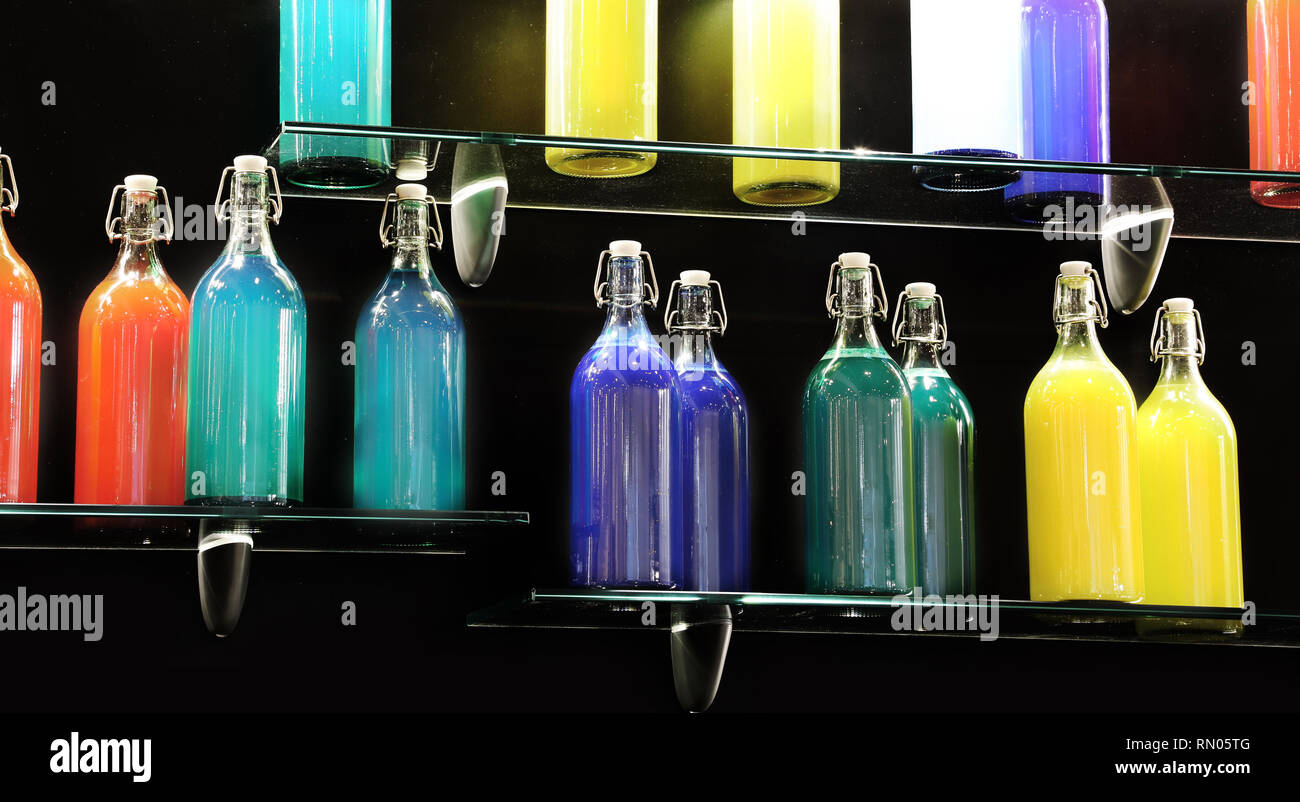 bar shelf with many colorful glass bottles without labels with liqueurs ...