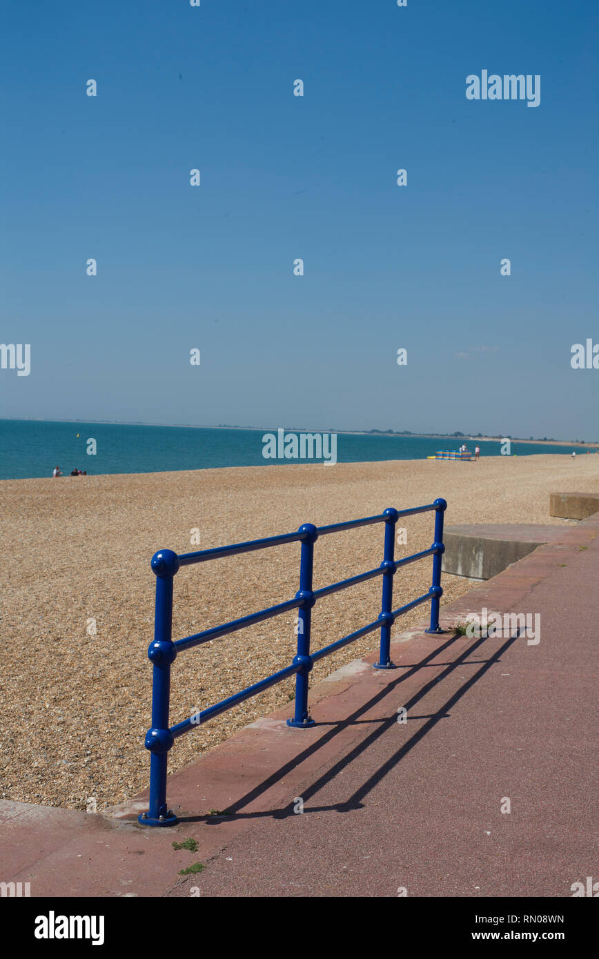 Blue railing by a shingle beach Stock Photo - Alamy
