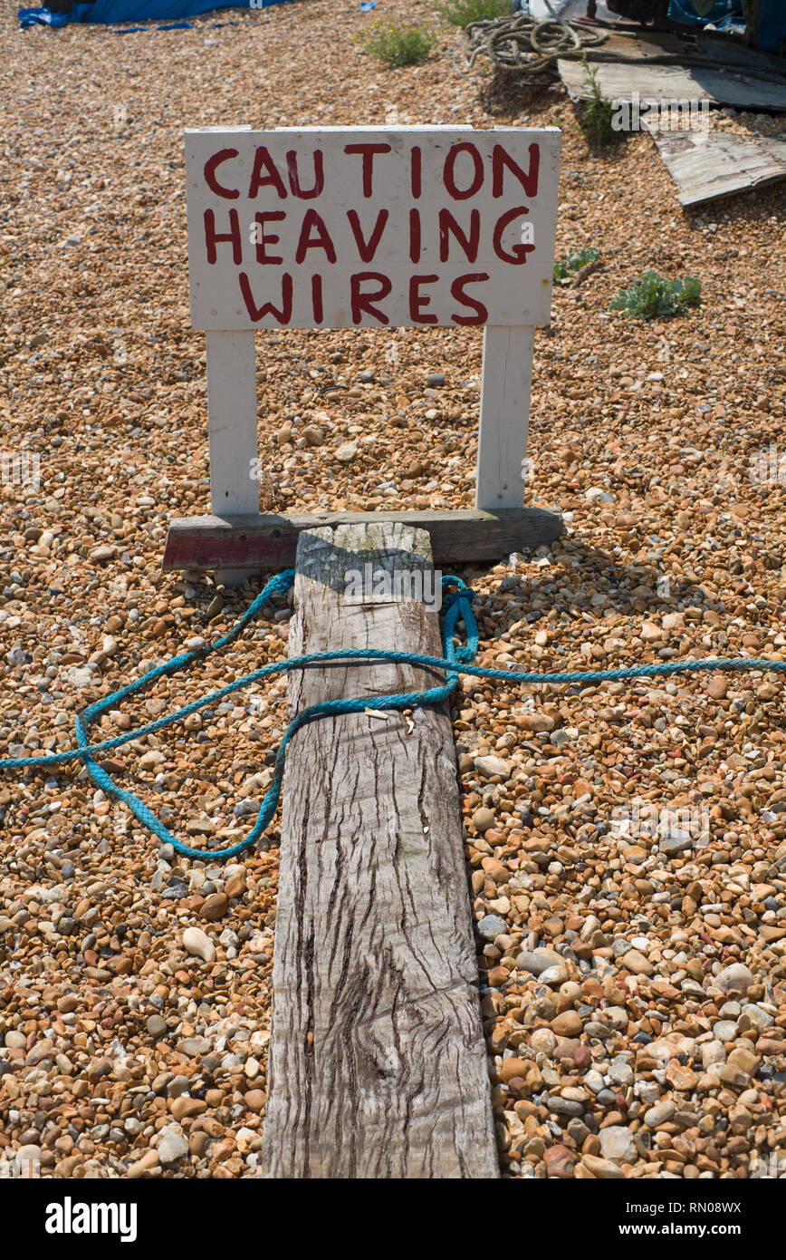 'Caution Heaving Wires' sign on a shingle beach Stock Photo - Alamy