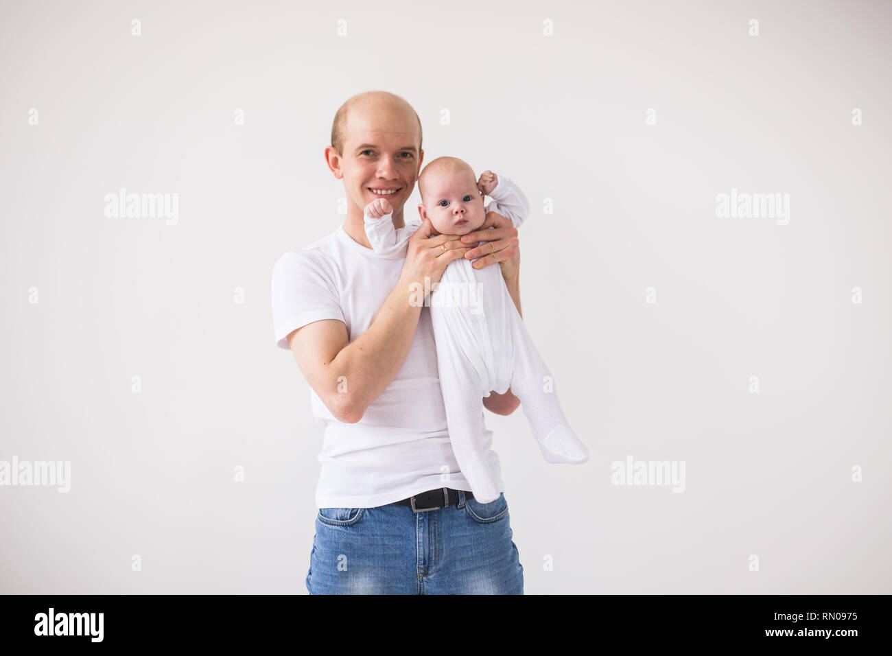 Infant, family and fatherhood concept - happy bald father holding baby ...
