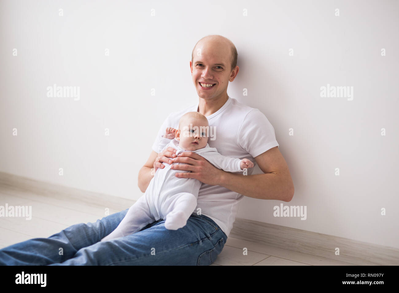 Infant, family and fatherhood concept - happy bald father holding baby ...