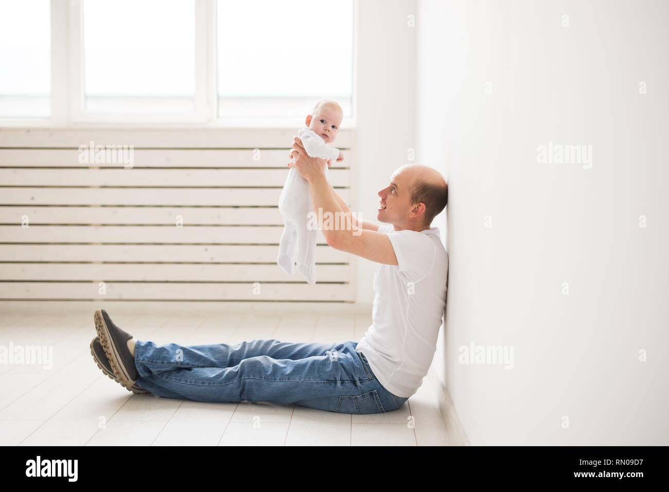 Parenting, family and fatherhood concept - Bald father sitting on the ...
