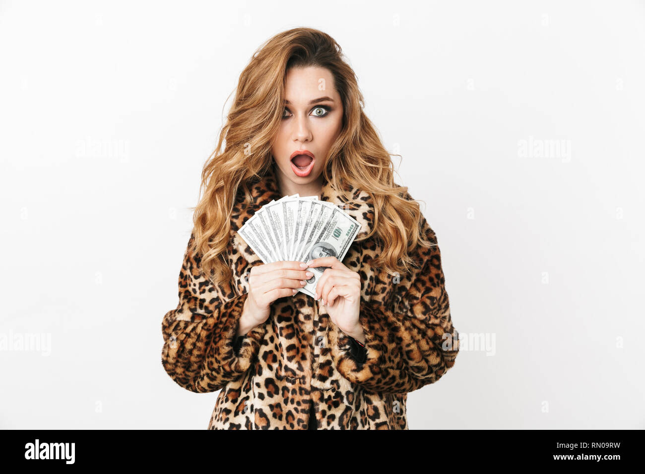 Beautiful young woman wearing leopard coat standing isolated over white ...