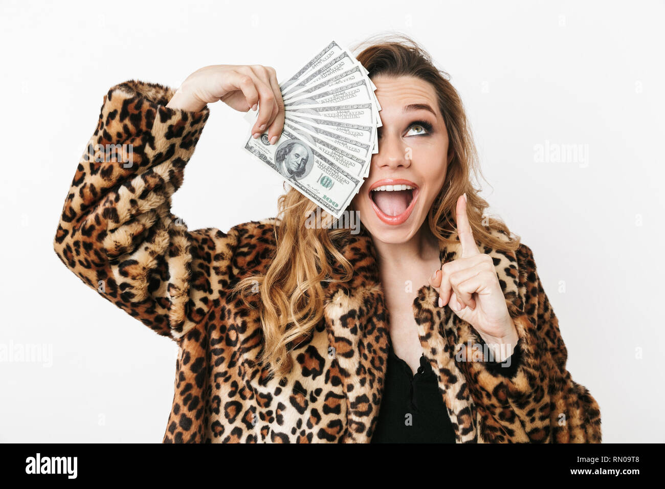 Beautiful young woman wearing leopard coat standing isolated over white ...