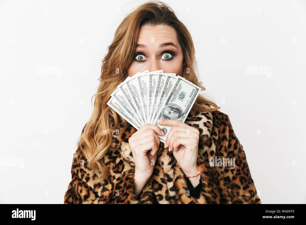 Beautiful young woman wearing leopard coat standing isolated over white ...