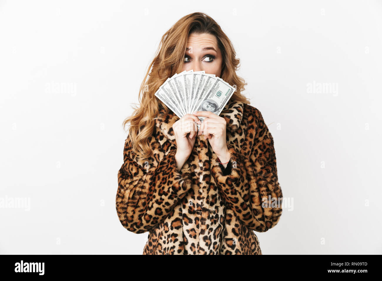 Beautiful young woman wearing leopard coat standing isolated over white ...