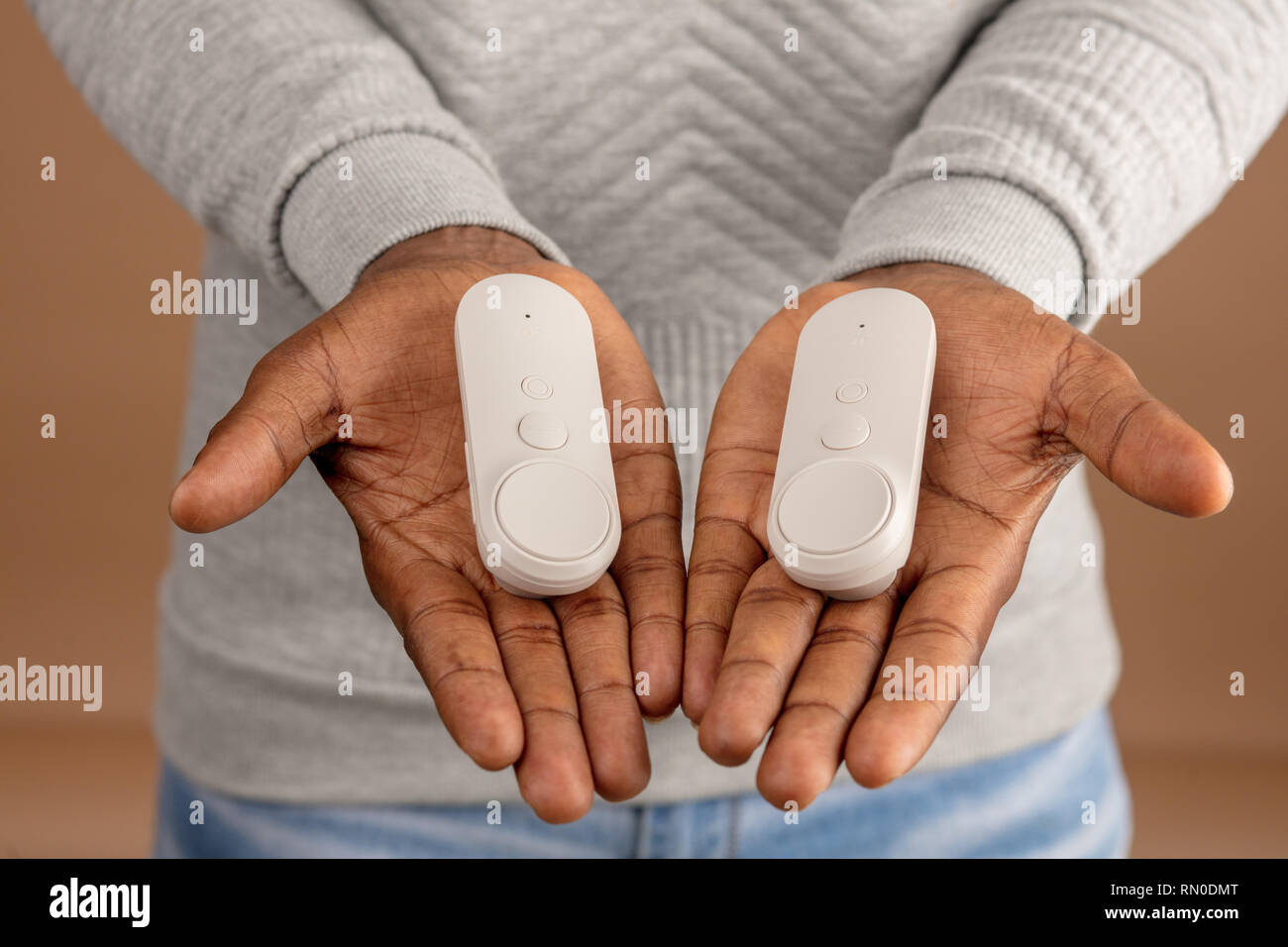 Hands of dark-skinned man holding handheld controllers from virtual ...