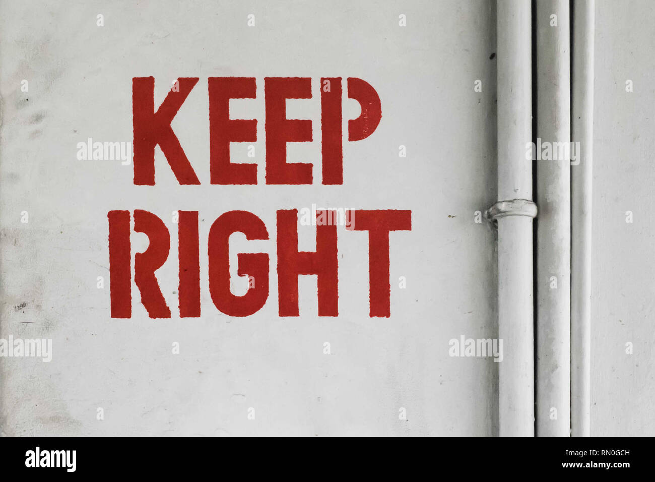 White painted wall with a KEEP RIGHT signage in red color Stock Photo ...