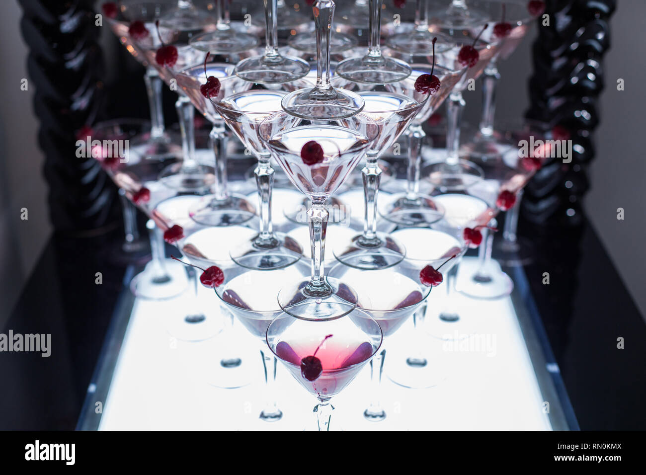 Pyramid of martini glasses with cherries on a party Stock Photo - Alamy