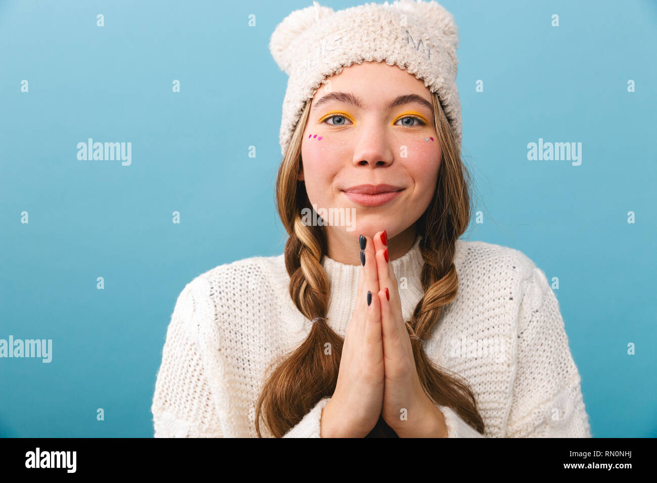 Lovely young girl wearing winter clothes standing isolated over blue ...