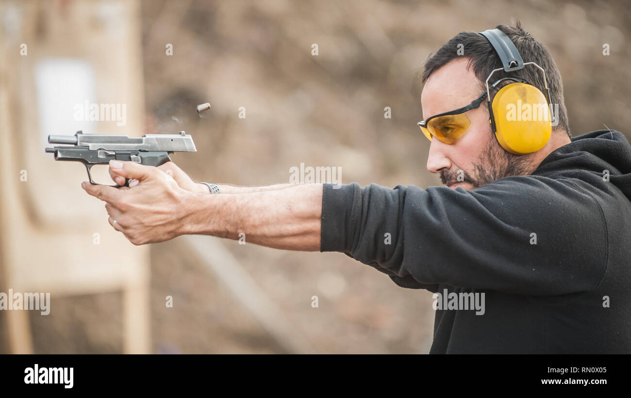 Detail view of shooter holding gun and training tactical shooting ...