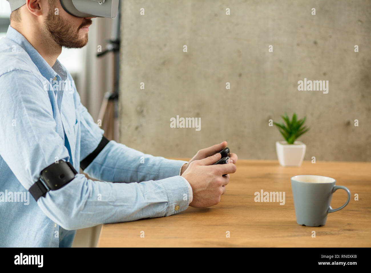 Hands holding controllers from virtual reality headset. Grey background ...