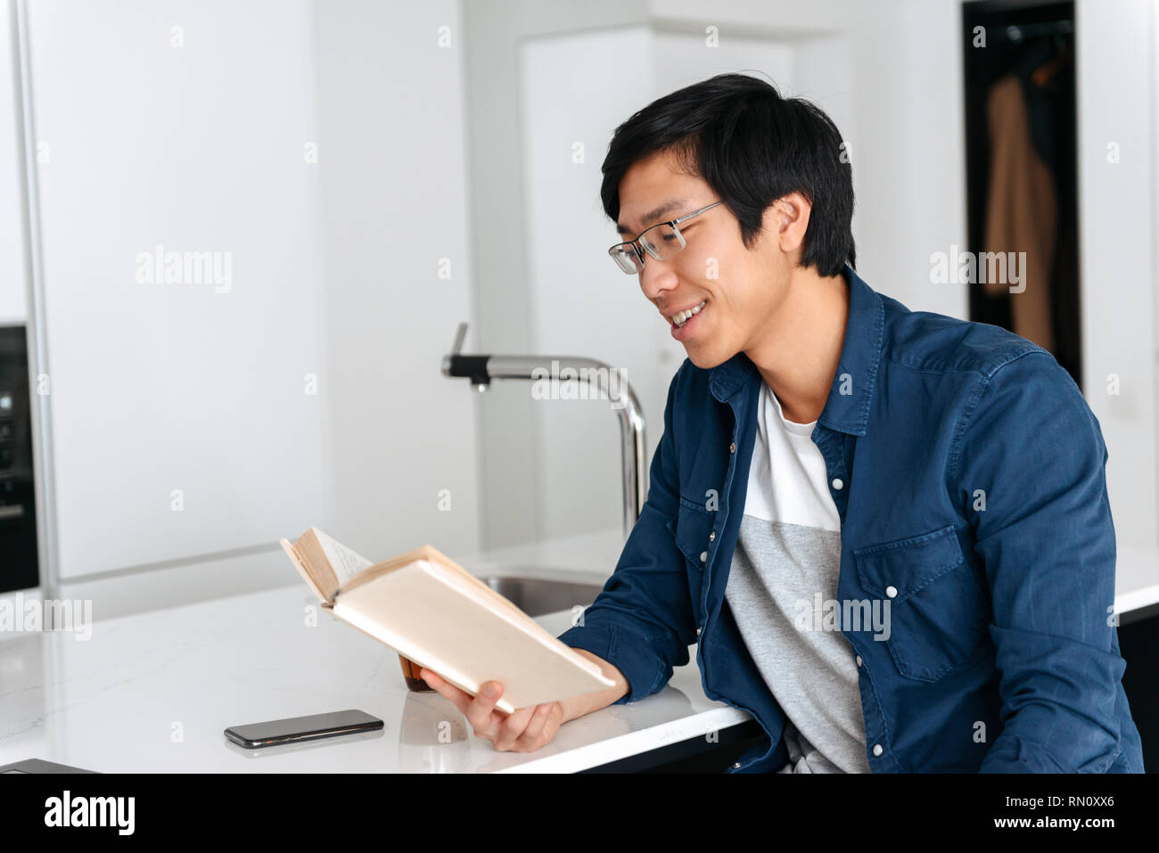 Positive asian man reading book hi-res stock photography and images - Alamy