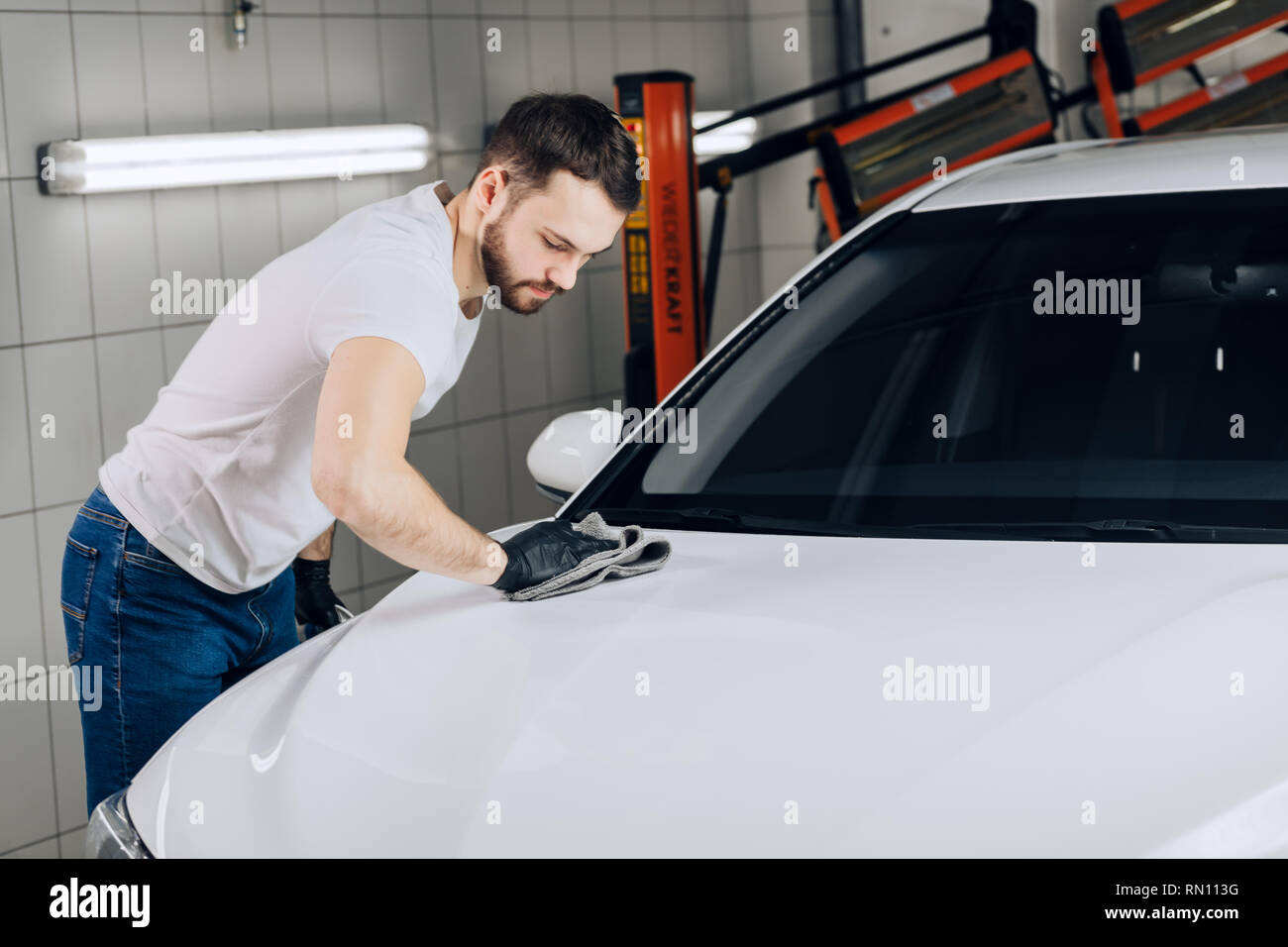 serious handsome man cleaning car with microfiber cloth, close up photo ...