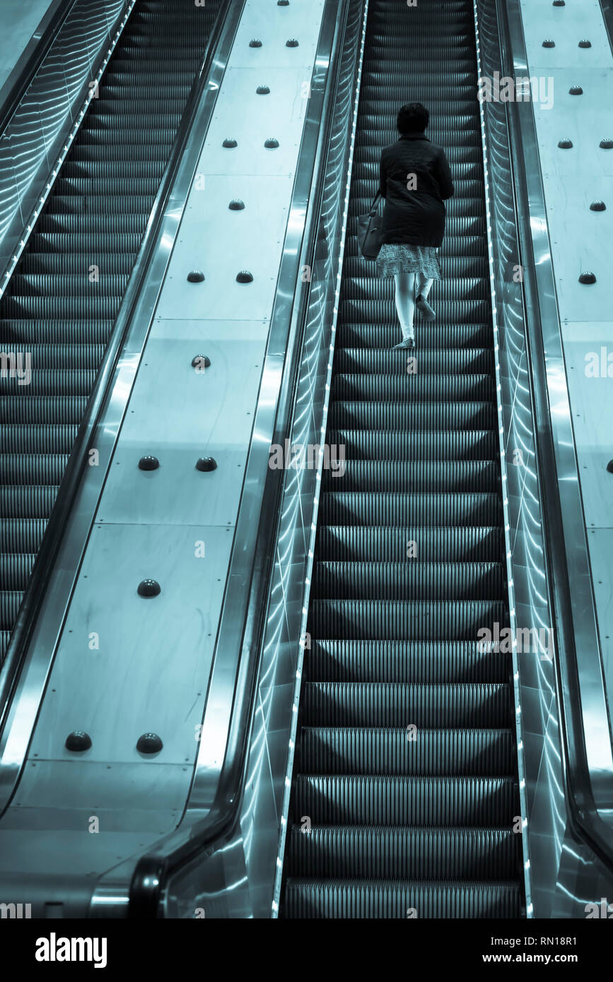 Woman walking up an escalator, Wynyard Railway Station escalator ...