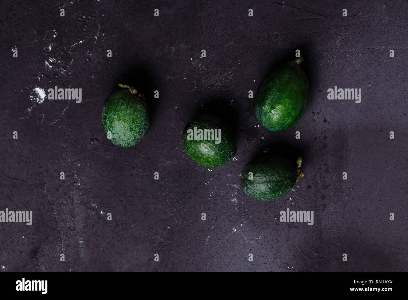 Tropical fruit, raw organic green feijoa on a dark black background ...