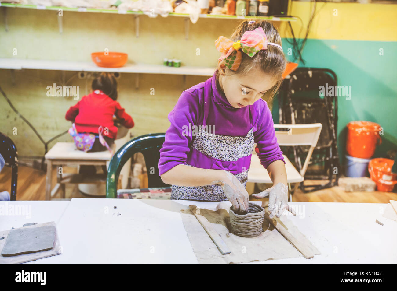 Child pottery workshop, portrait of little girl working with clay ...