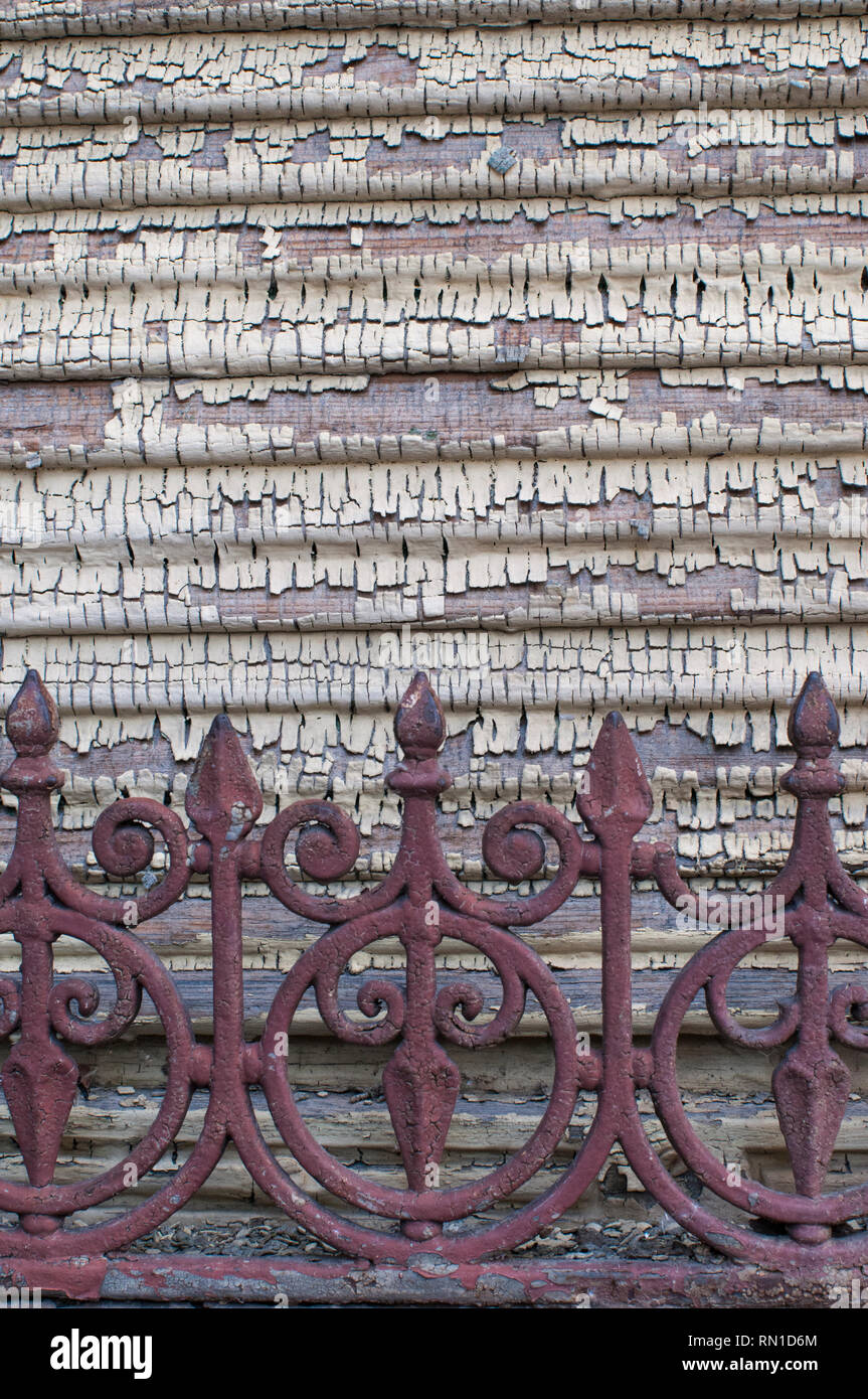 Old, chipped paint on the wooden facade. An old weathered, pastel fence ...