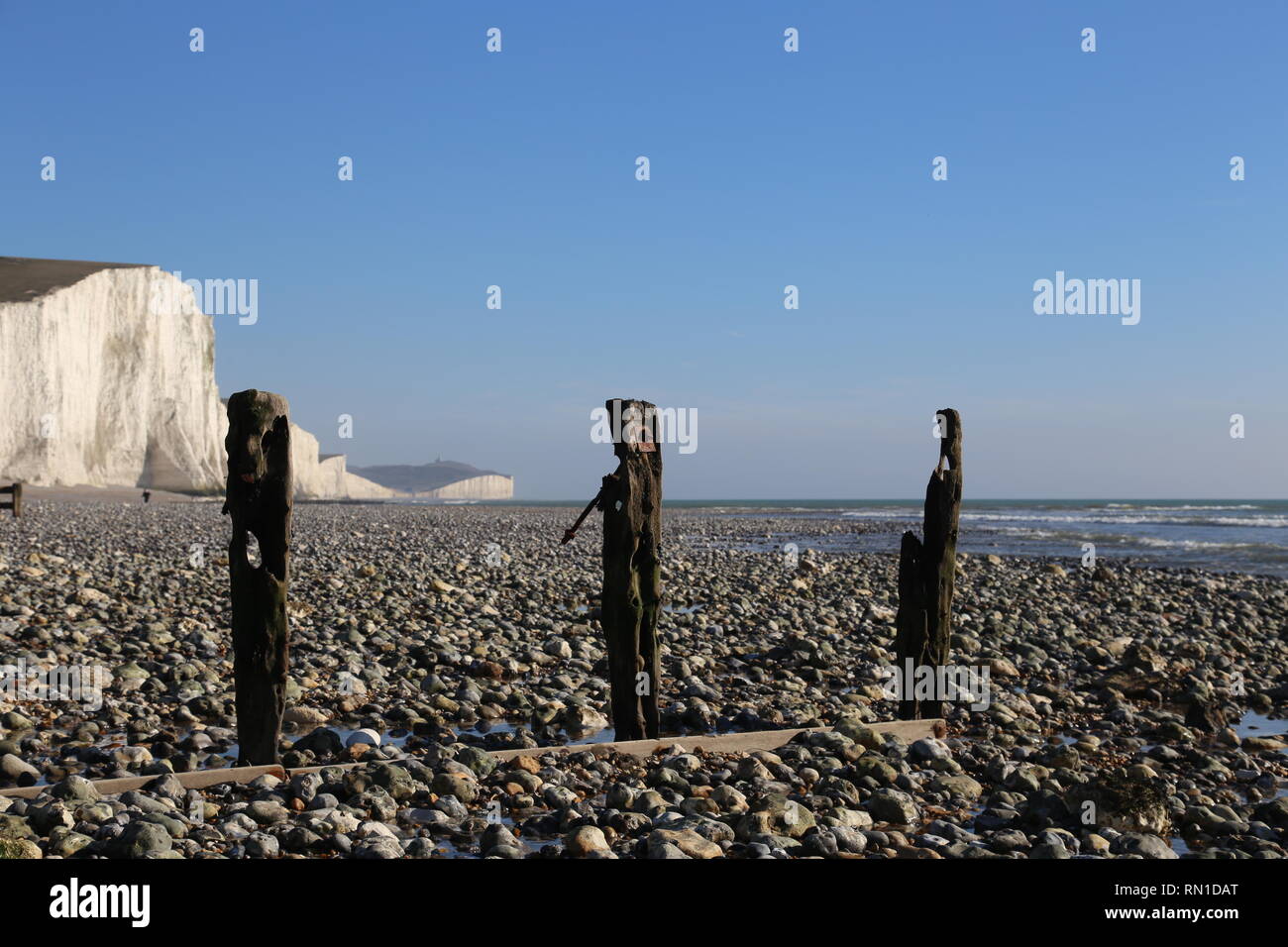 Rotten wooden beach break with chalk cliff Stock Photo - Alamy