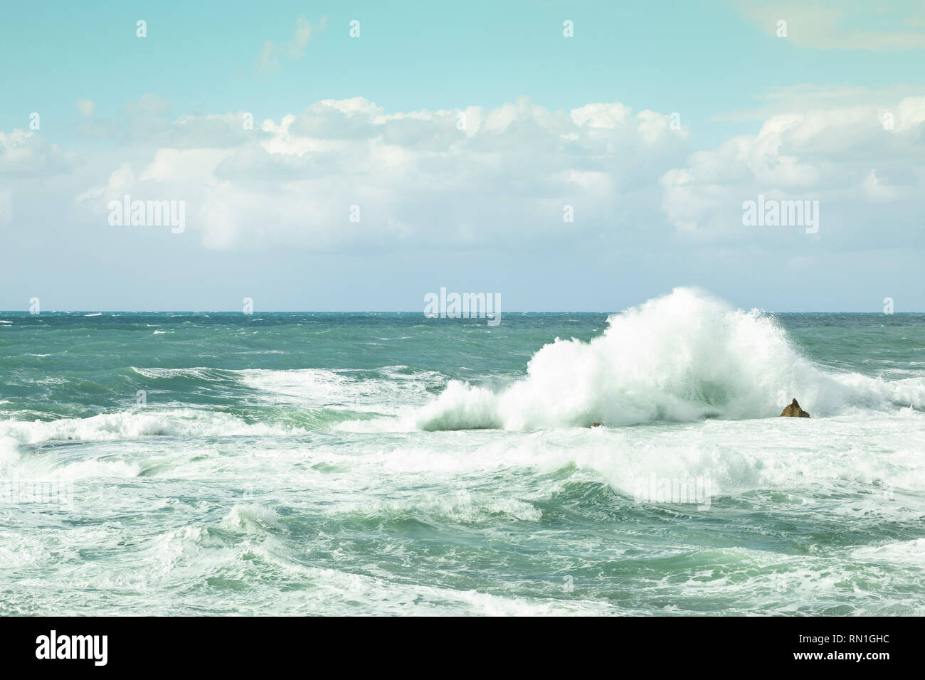 A beautiful turquoise blue big waves rolling over the sea and cloudy ...
