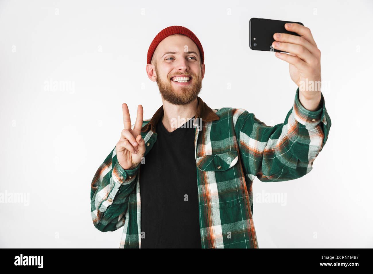 Image of handsome guy wearing hat and plaid shirt taking selfie photo ...