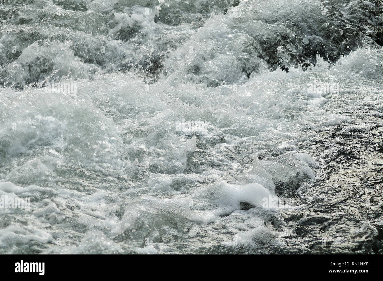 rapids causing whitewater and air bubbles in shallow bed or a river ...