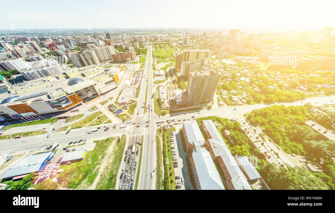 Aerial city view with crossroads and roads, houses, buildings, parks and parking lots. Sunny ...