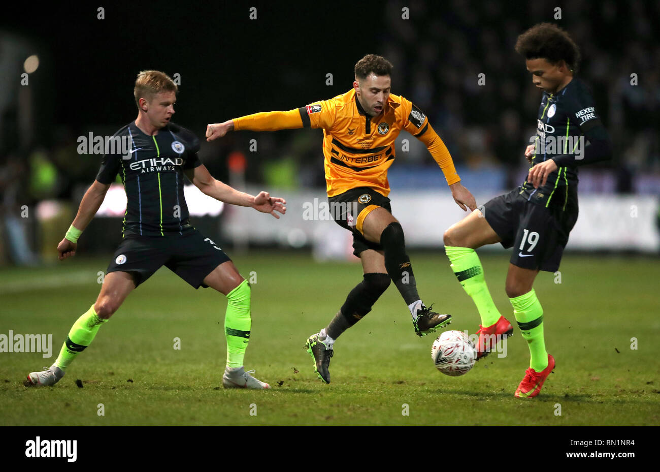 Newport County's Robbie Willmott (centre) battles for the ball with ...