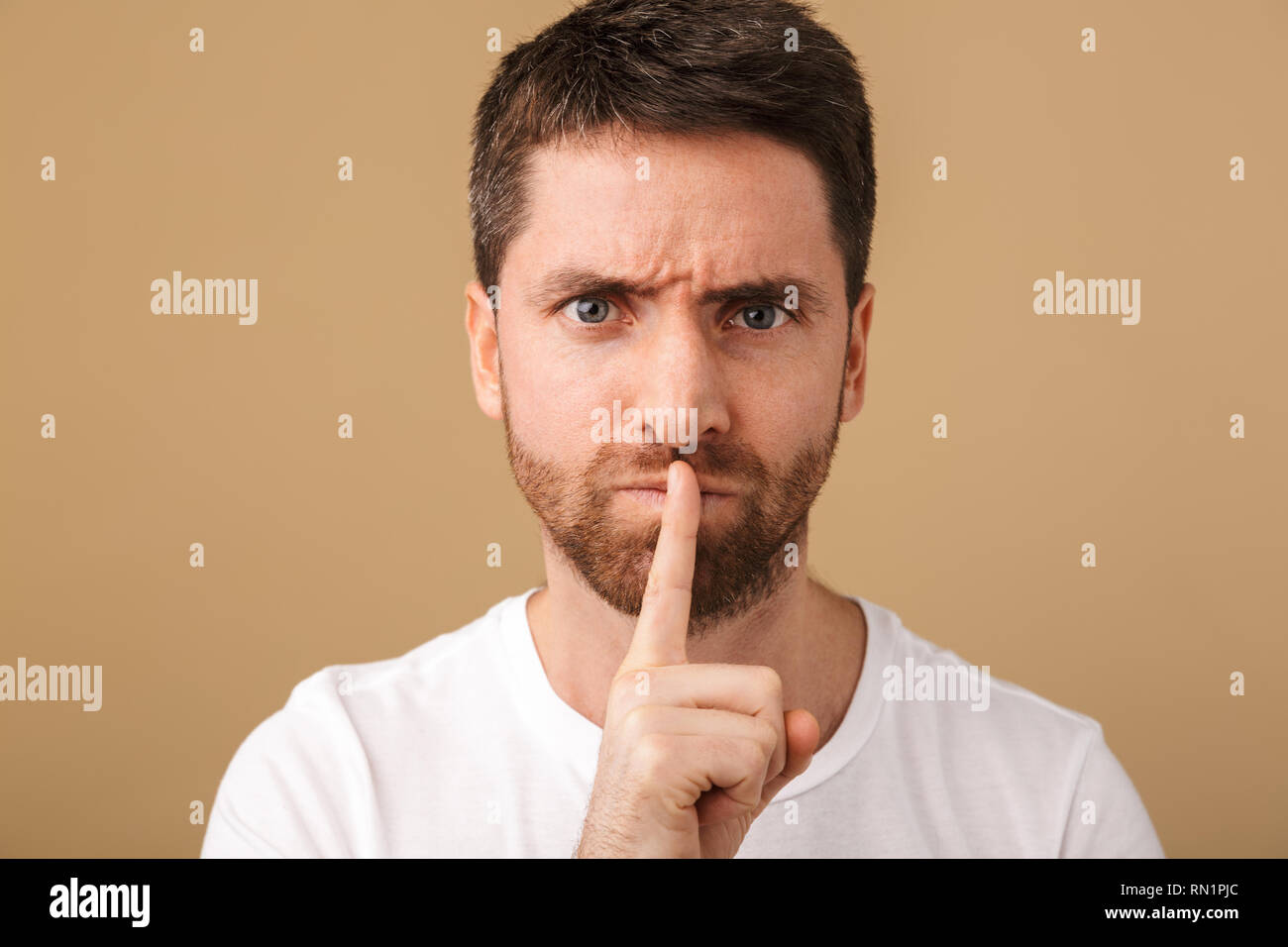 Portrait of a confident young man casually dressed standing isolated ...