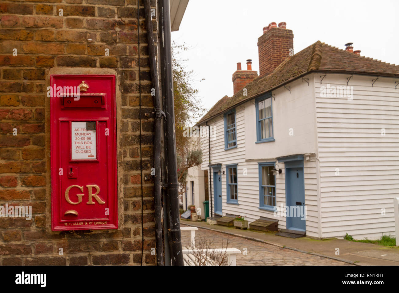 Old wall mounted post box (closed) in red brick wall on side of a road ...