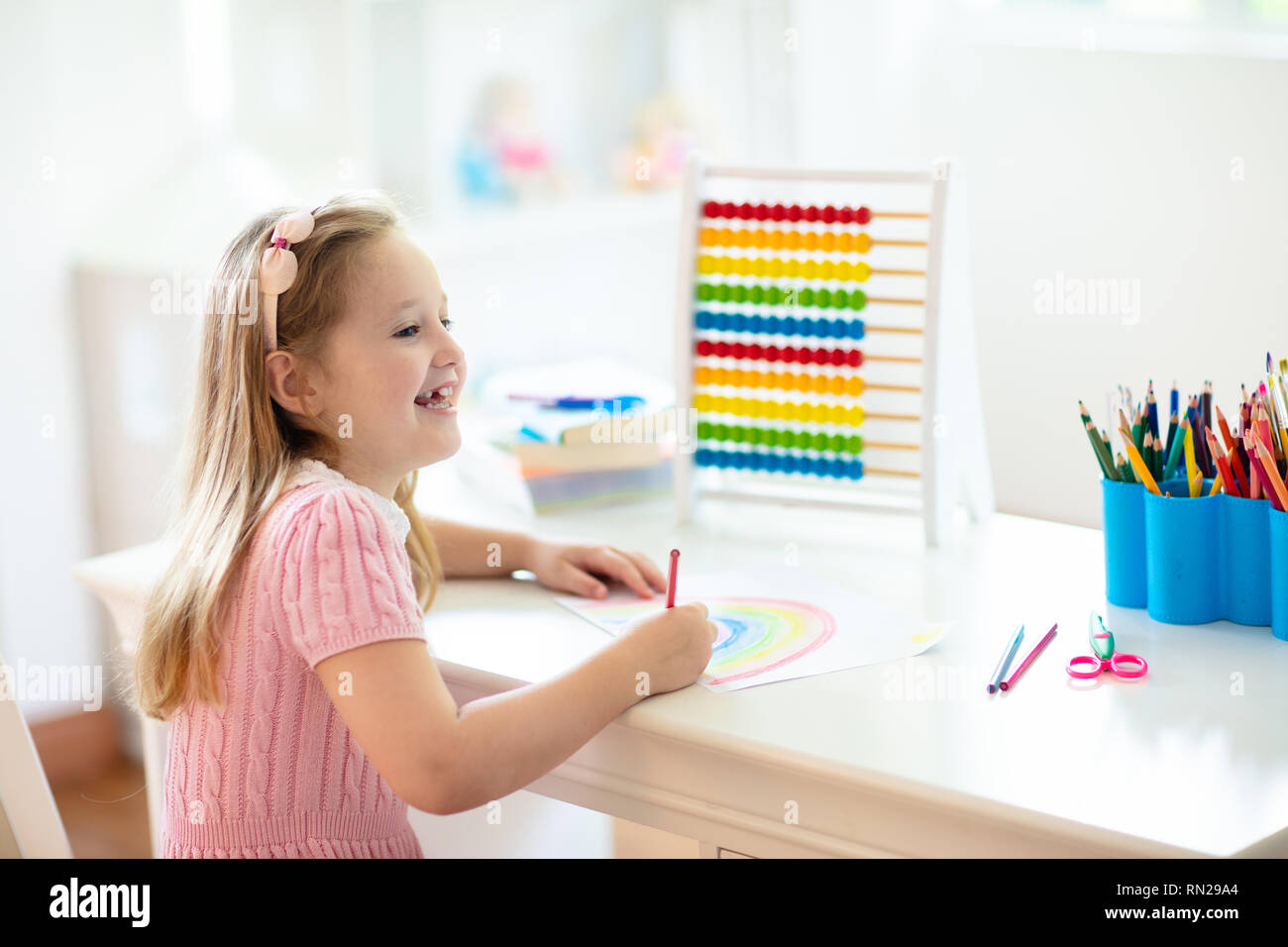 Child drawing rainbow. Kid painting at home. Little girl doing homework ...