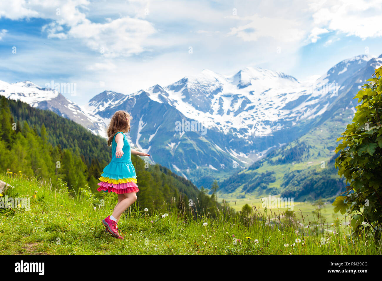 Children hiking in Alps mountains. Kids look at snow covered mountain ...