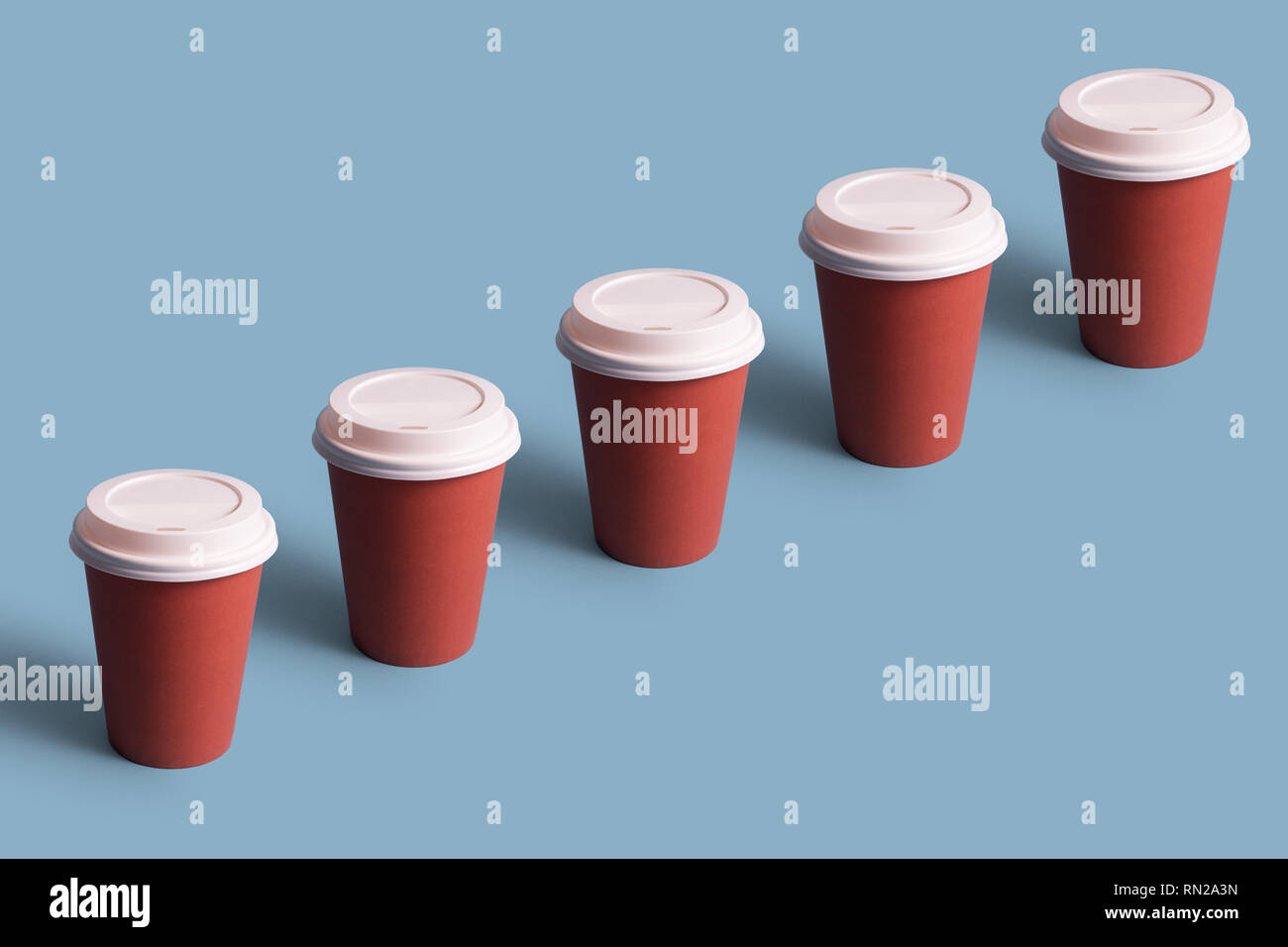 Disposable coffee cups organized in a row over blue background Stock ...