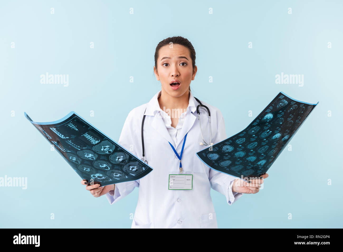 Photo of a young shocked woman doctor posing isolated over blue wall ...