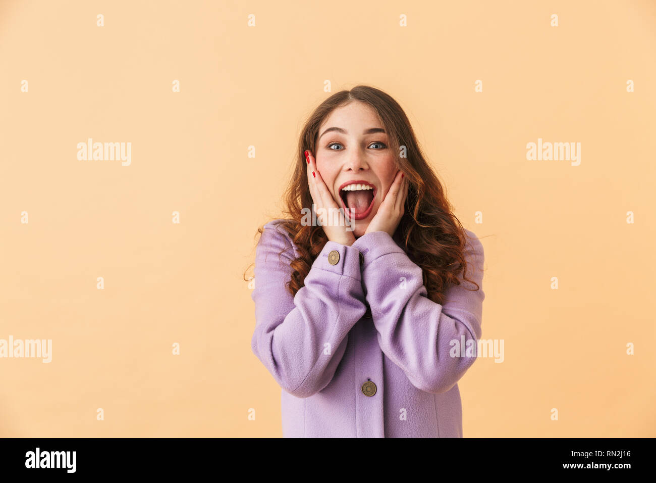 Portrait of shocked girl 20s in coat screaming while standing isolated ...