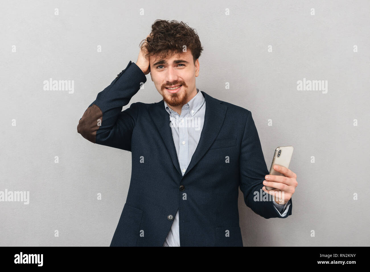 Photo of a handsome confused displeased young business man isolated ...
