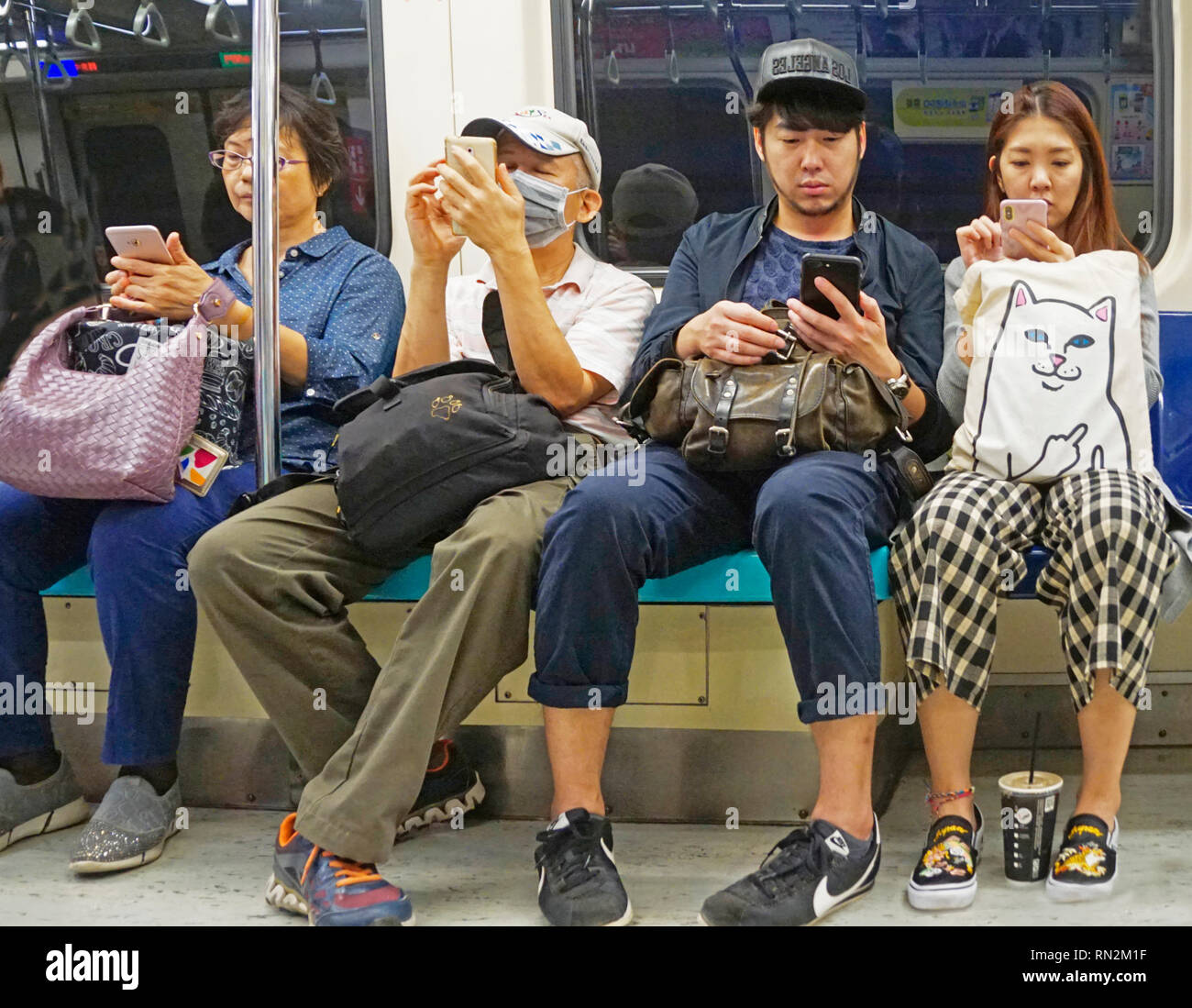 Taipei Metro (MRT) subway passengers staring at their smart phones ...