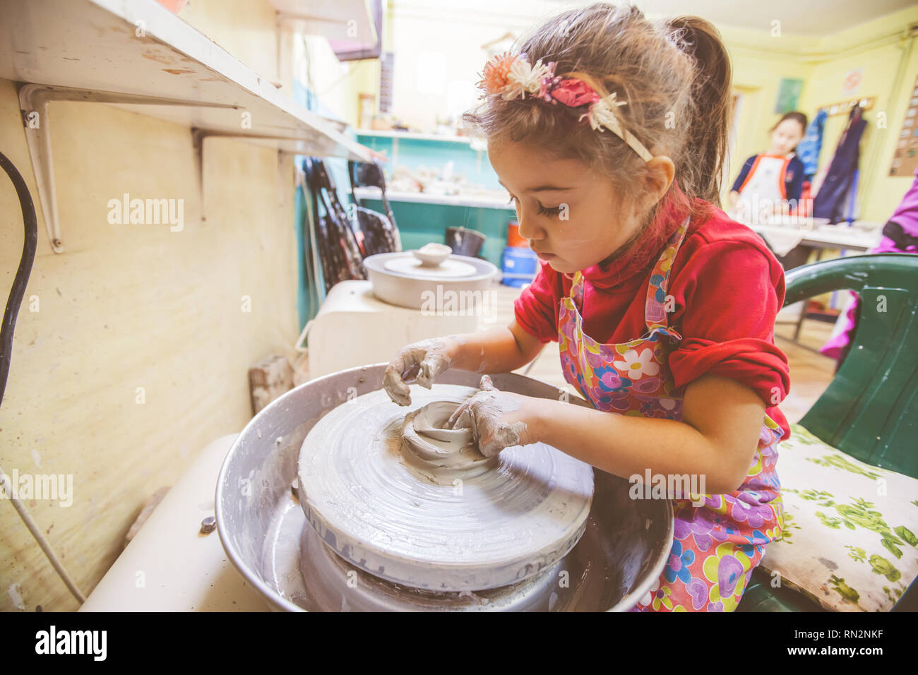Little girl creative learning at potter workshop - Child shaping clay ...