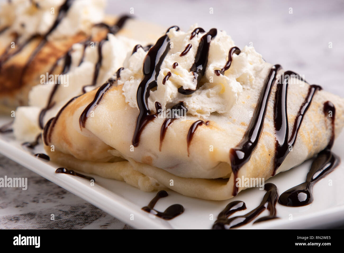 european pancakes, sweet crepe with topping on white long plate Stock ...