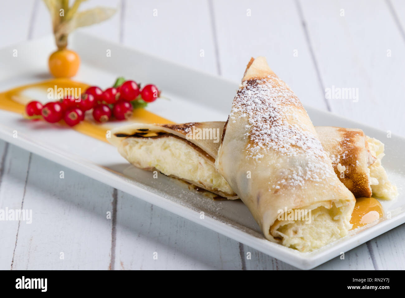 european pancakes, sweet crepe with topping on white long plate Stock ...