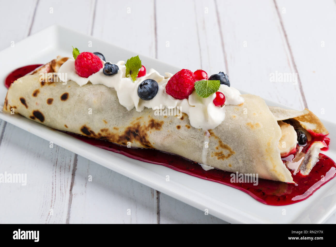 european pancakes, sweet crepe with topping on white long plate Stock ...