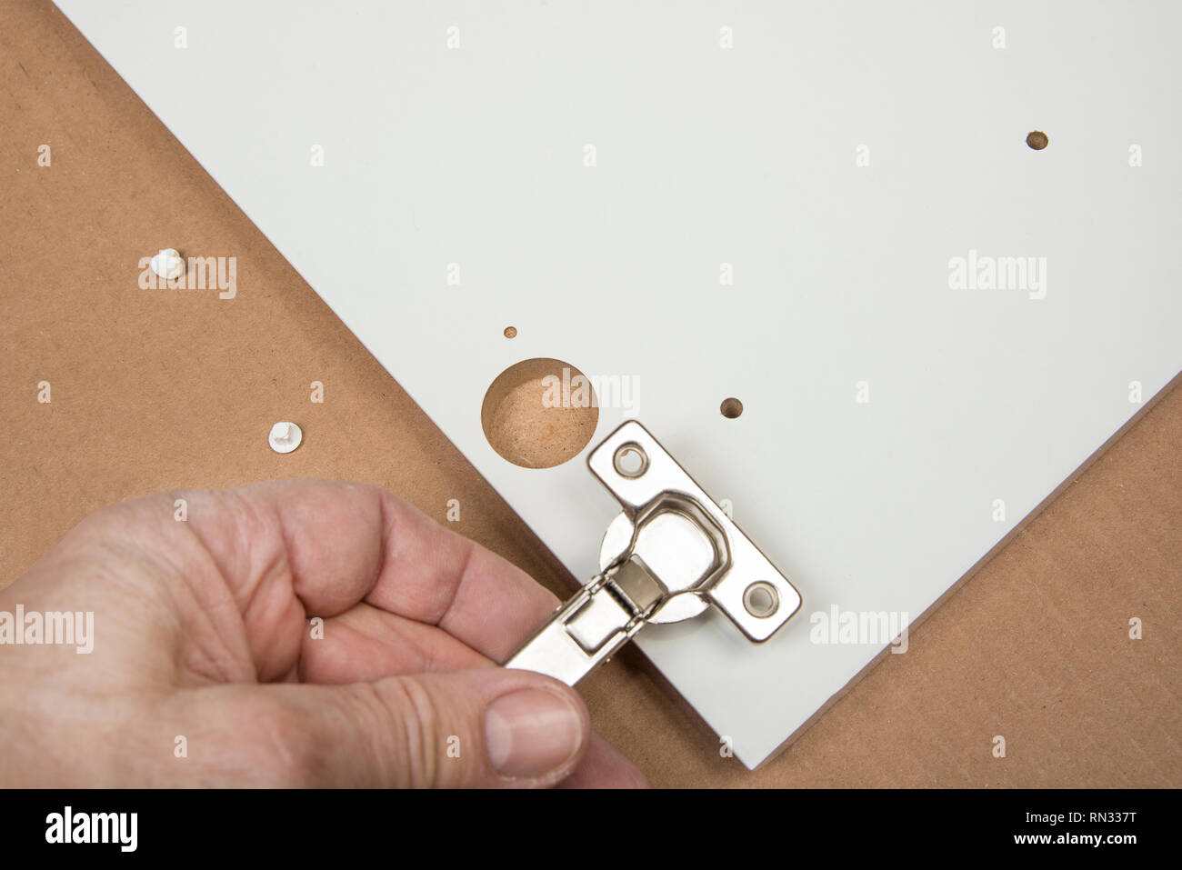 Handyman is assembling a cabinet. Furniture put together concept Stock ...