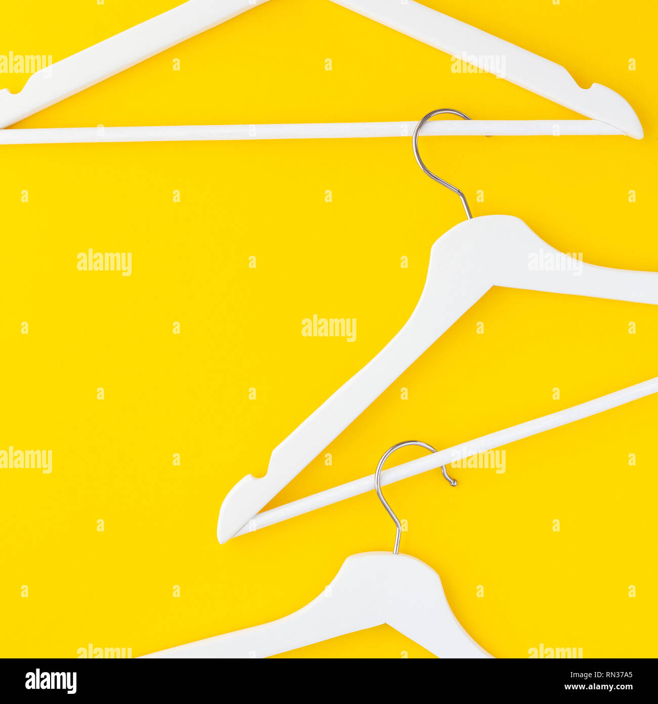 Creative top view flat lay white wooden hangers isolated bold yellow ...