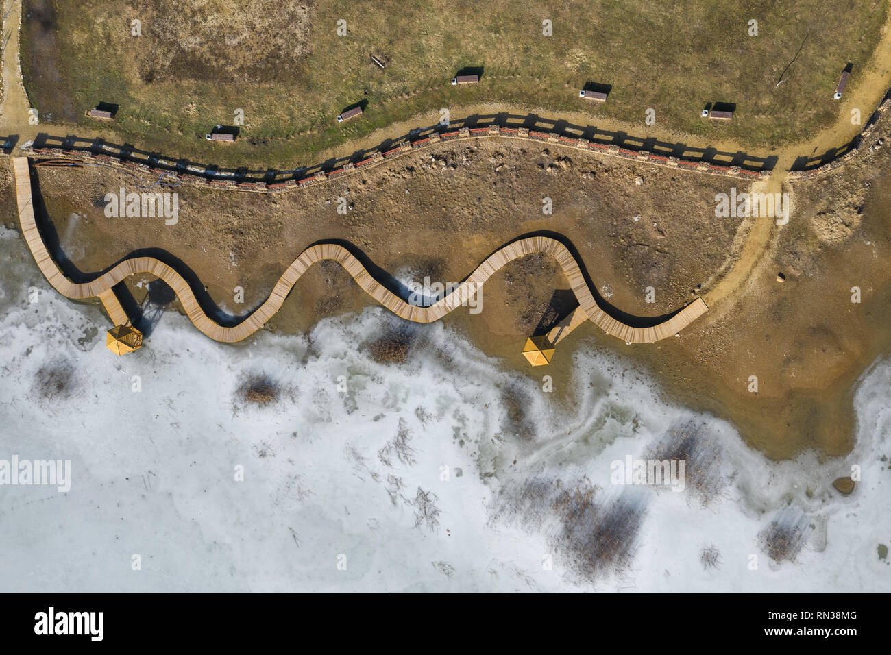 Aerial view of the winter frozen lake with wooden piers from above ...